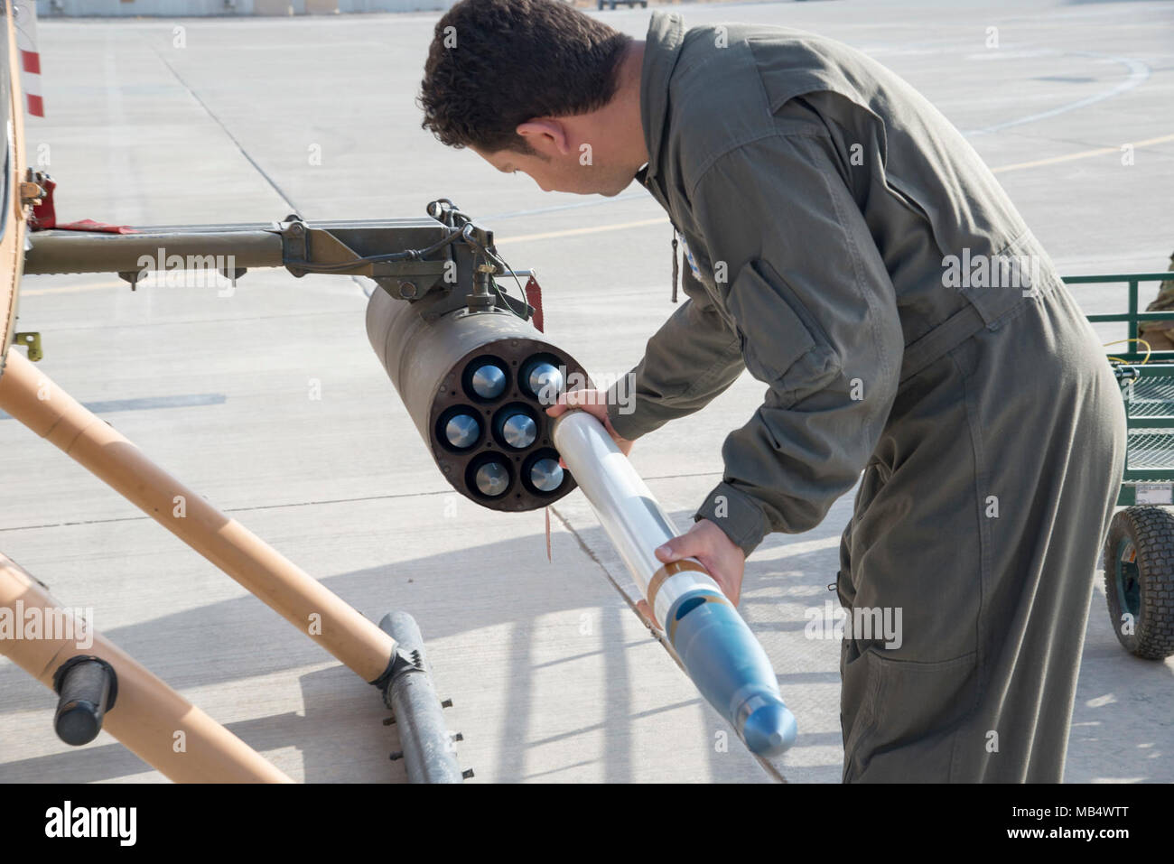 An Afghan Air Force MD-530 pilot loads a rocket into the aircrafts ...