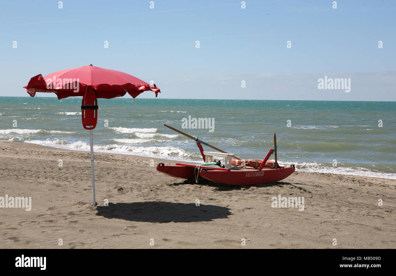 Red beach rescue boat and a the watcher's umbrella corner Stock Photo ...