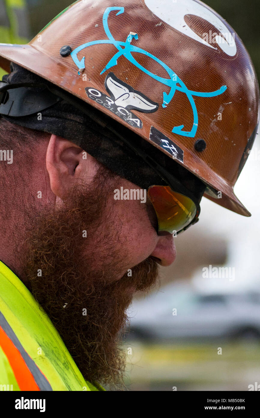 Justin Skelton, construction laborer, examines cement before working on ...