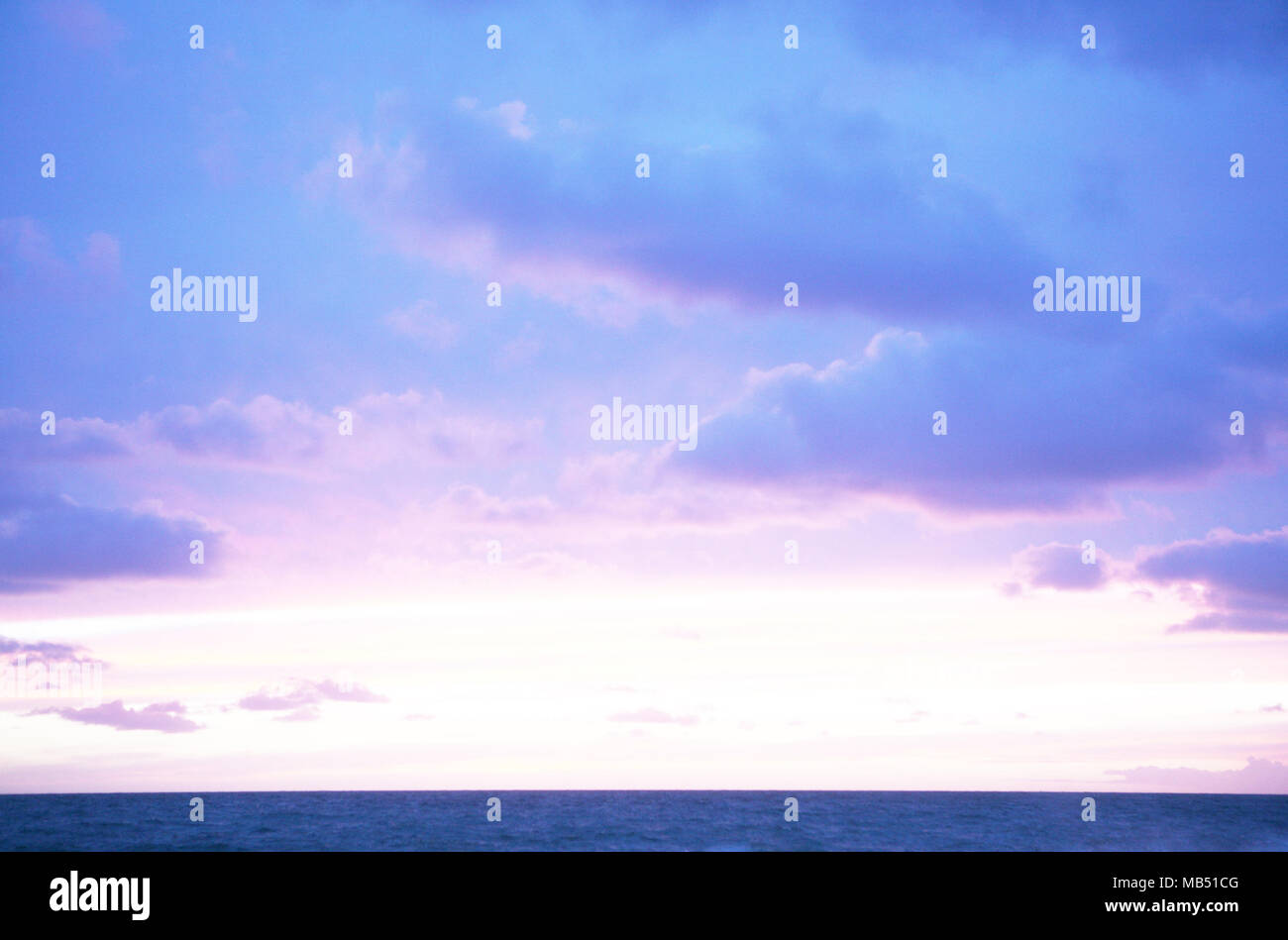 Red Sunset sky over the ocean with blue clouds Stock Photo - Alamy