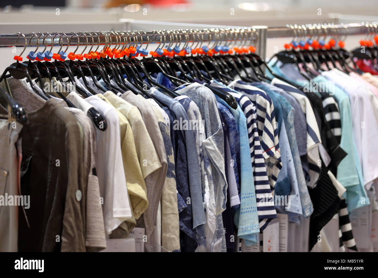 Row of clothes hanging in wardrobe or store Stock Photo - Alamy