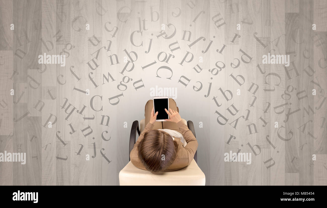 Letters with writer using tablet in a beige chair and an office space ...