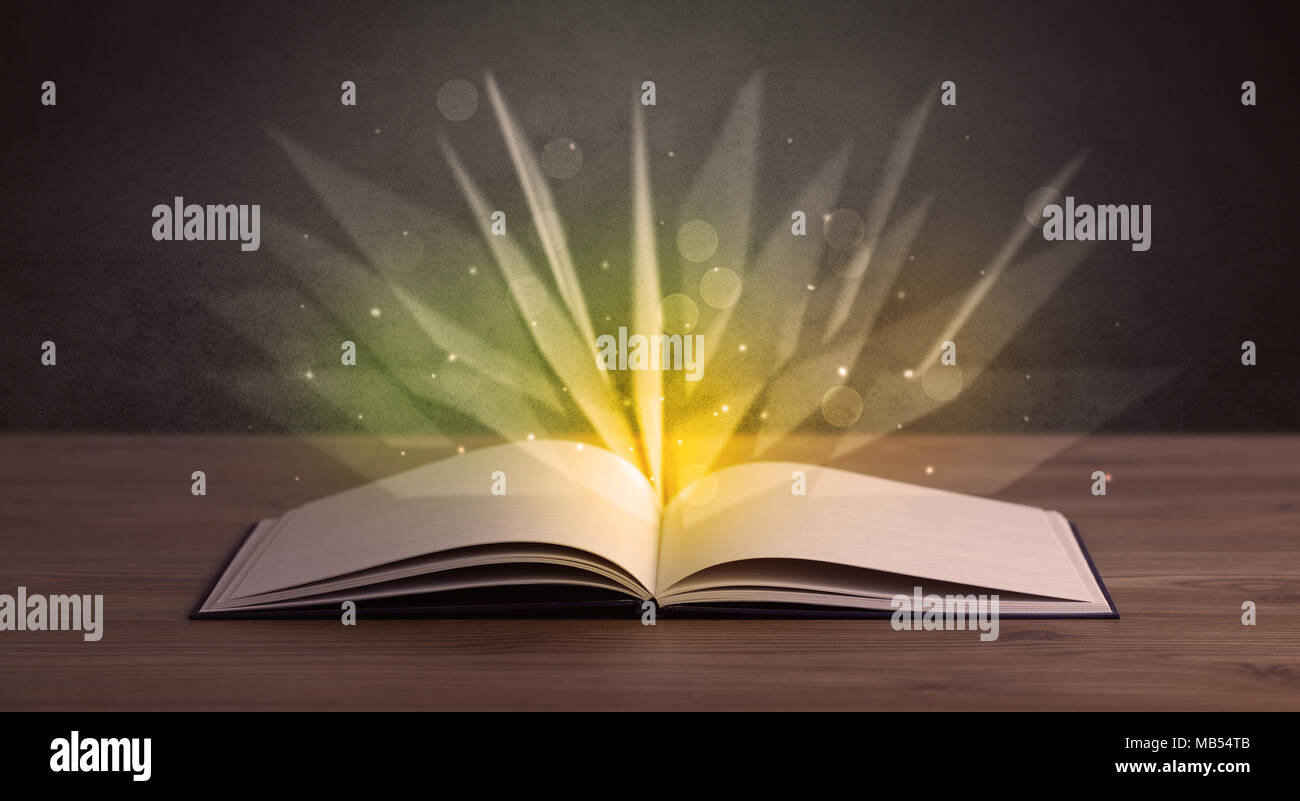 Yellow lights spreading from an open book Stock Photo - Alamy