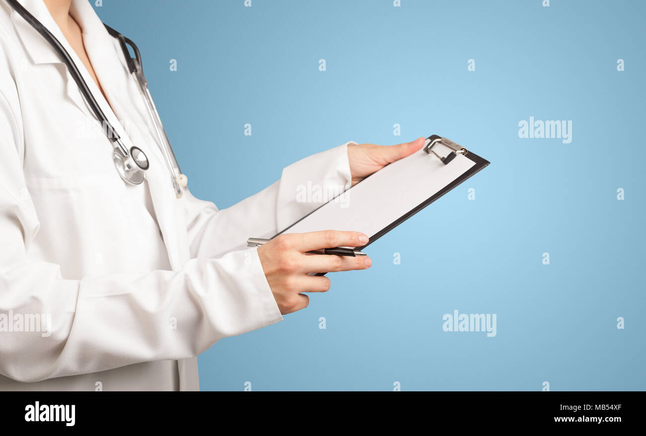 Female doctor holding notepad with blue background Stock Photo - Alamy