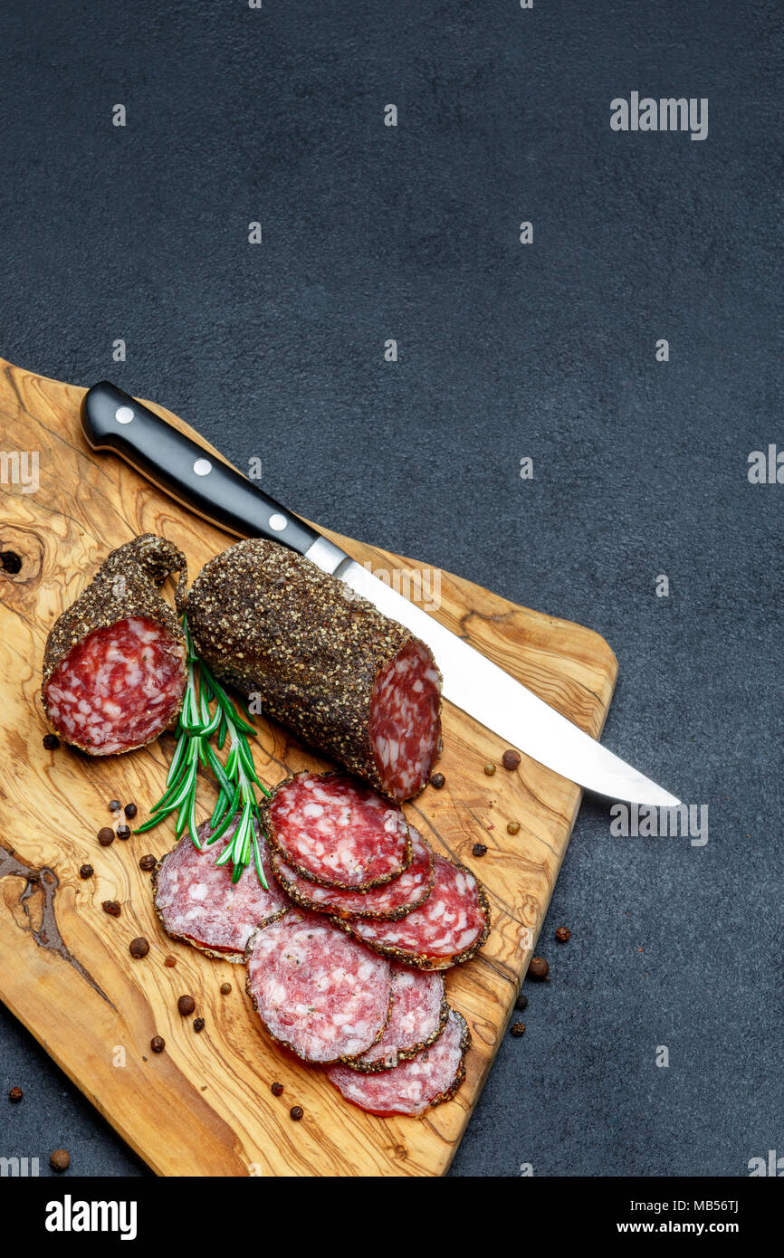 Dried organic salami sausage on wooden cutting board Stock Photo - Alamy