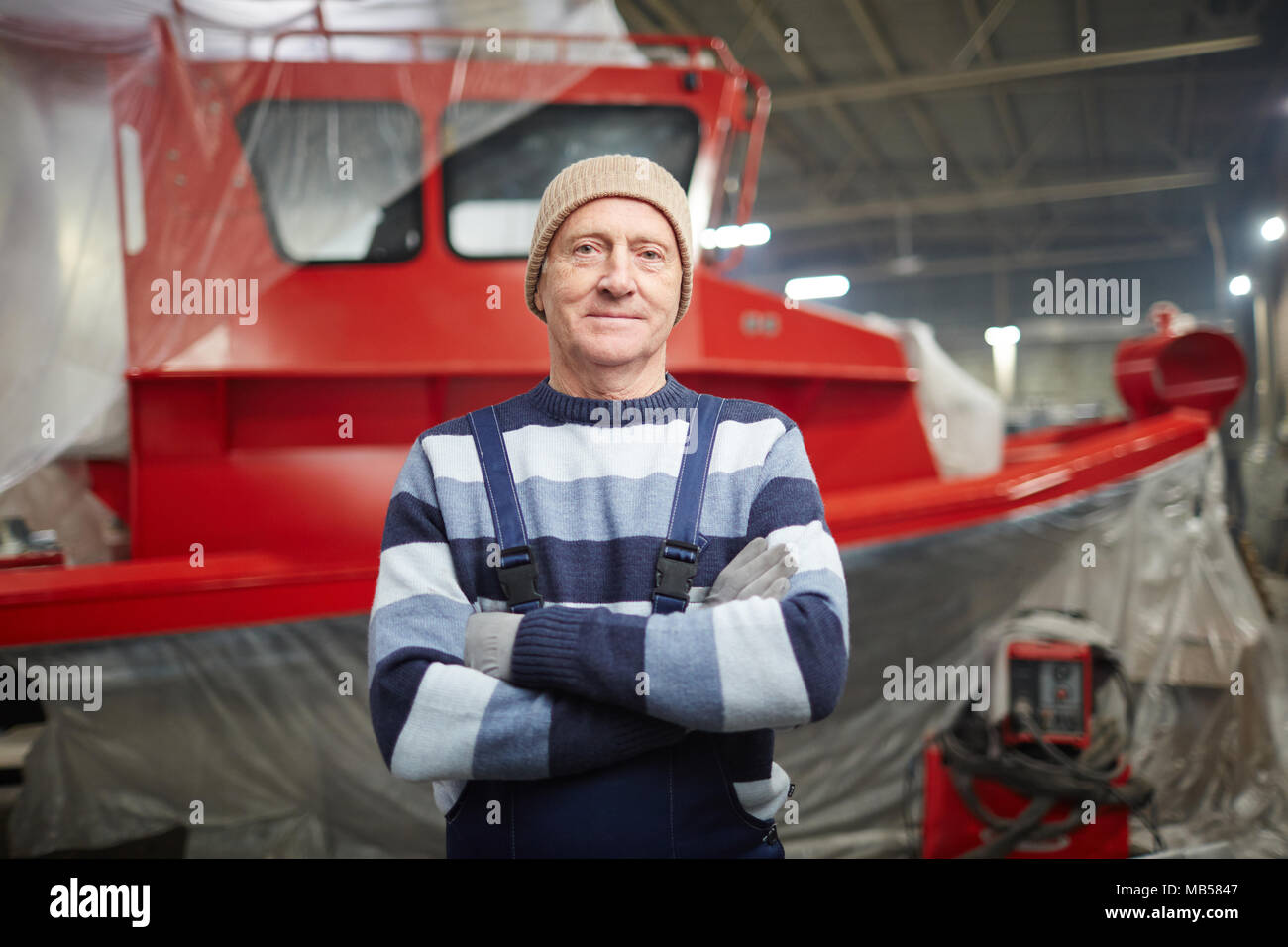 Mature experienced shipbuilding engineer standing on background of new ...