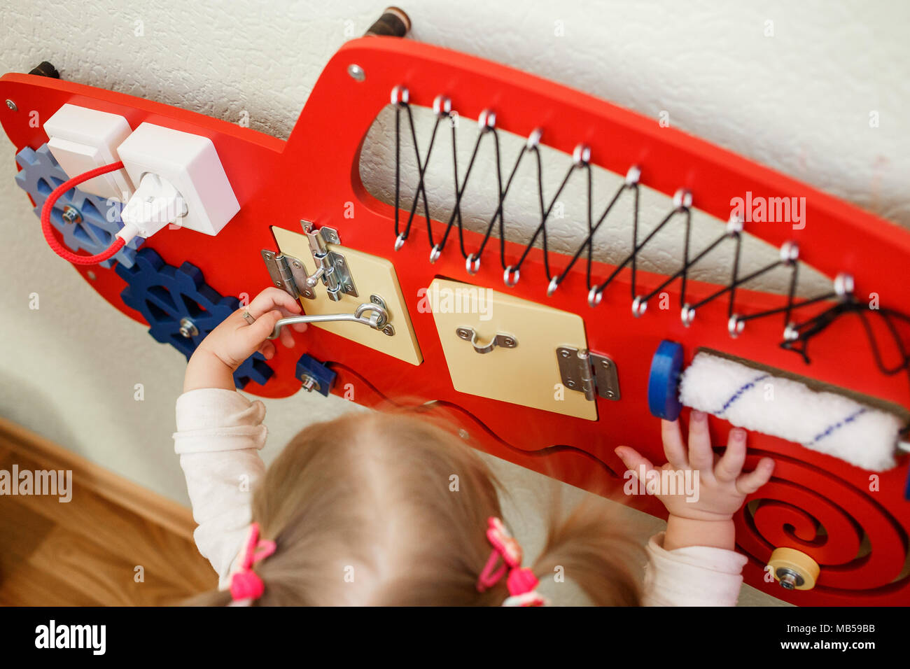 Cute toddlers playing with busy board at kindergarten Stock Photo - Alamy