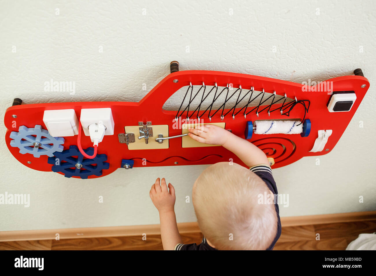 Cute toddlers playing with busy board at kindergarten Stock Photo - Alamy
