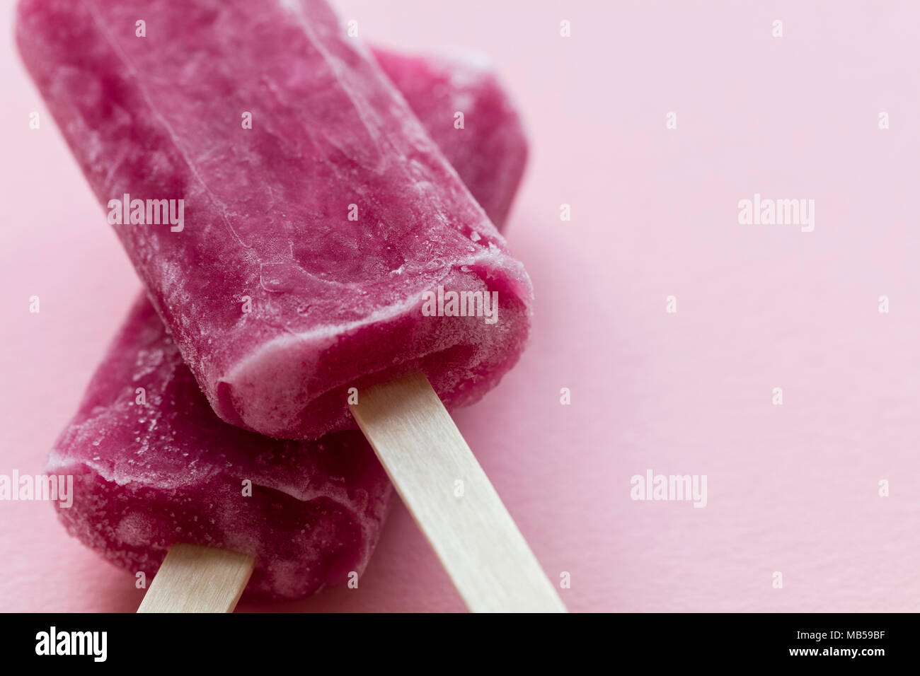 Raspberry flavour summertime ice lollies on a pink background Stock ...