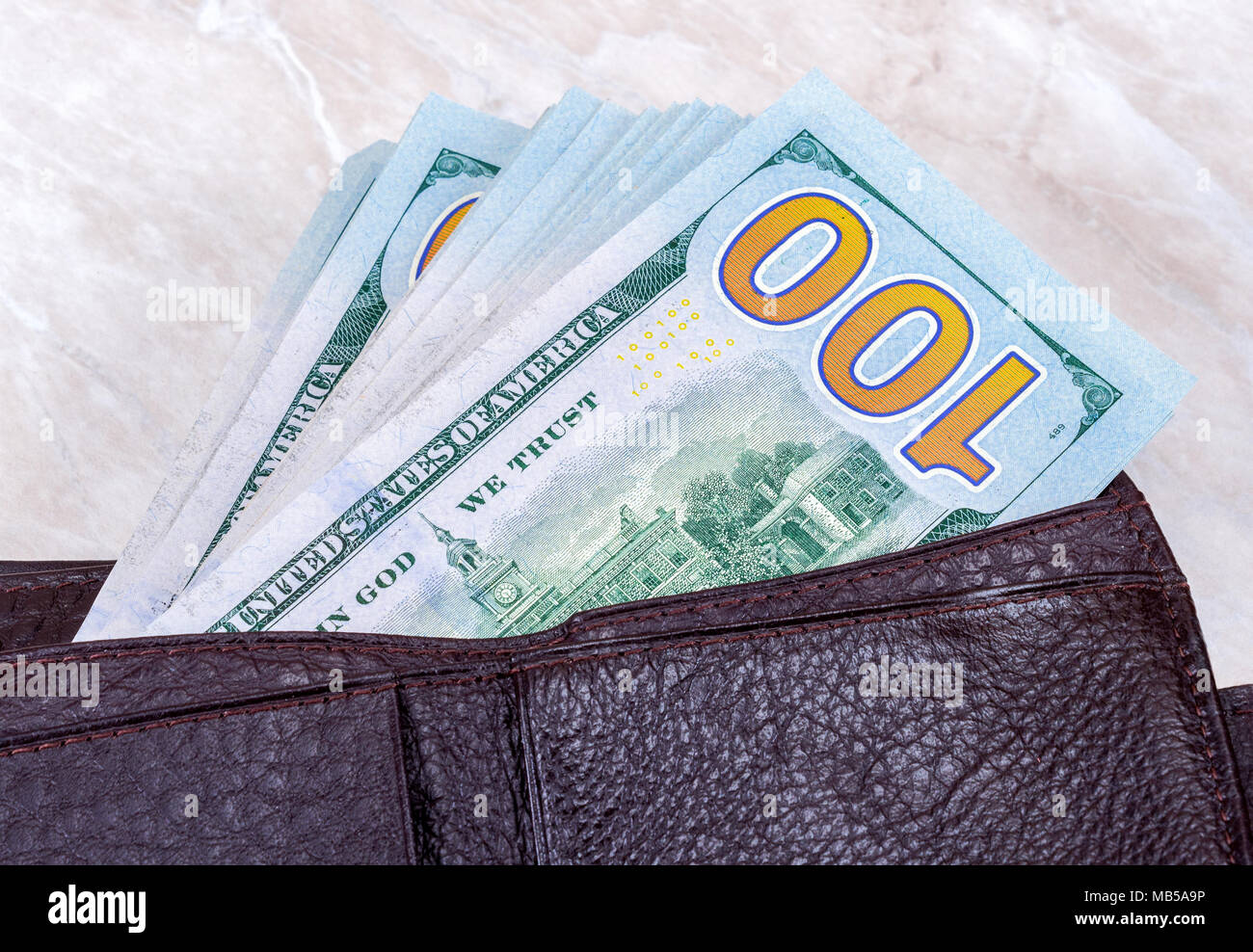 Open wallet with a heap of hundred dollar banknotes sticking out Stock ...