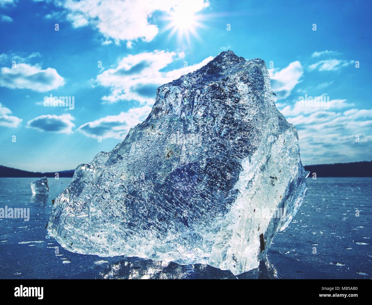 Sharp piece of ice. A symbol of harsh winter. The rays of the sun form ...