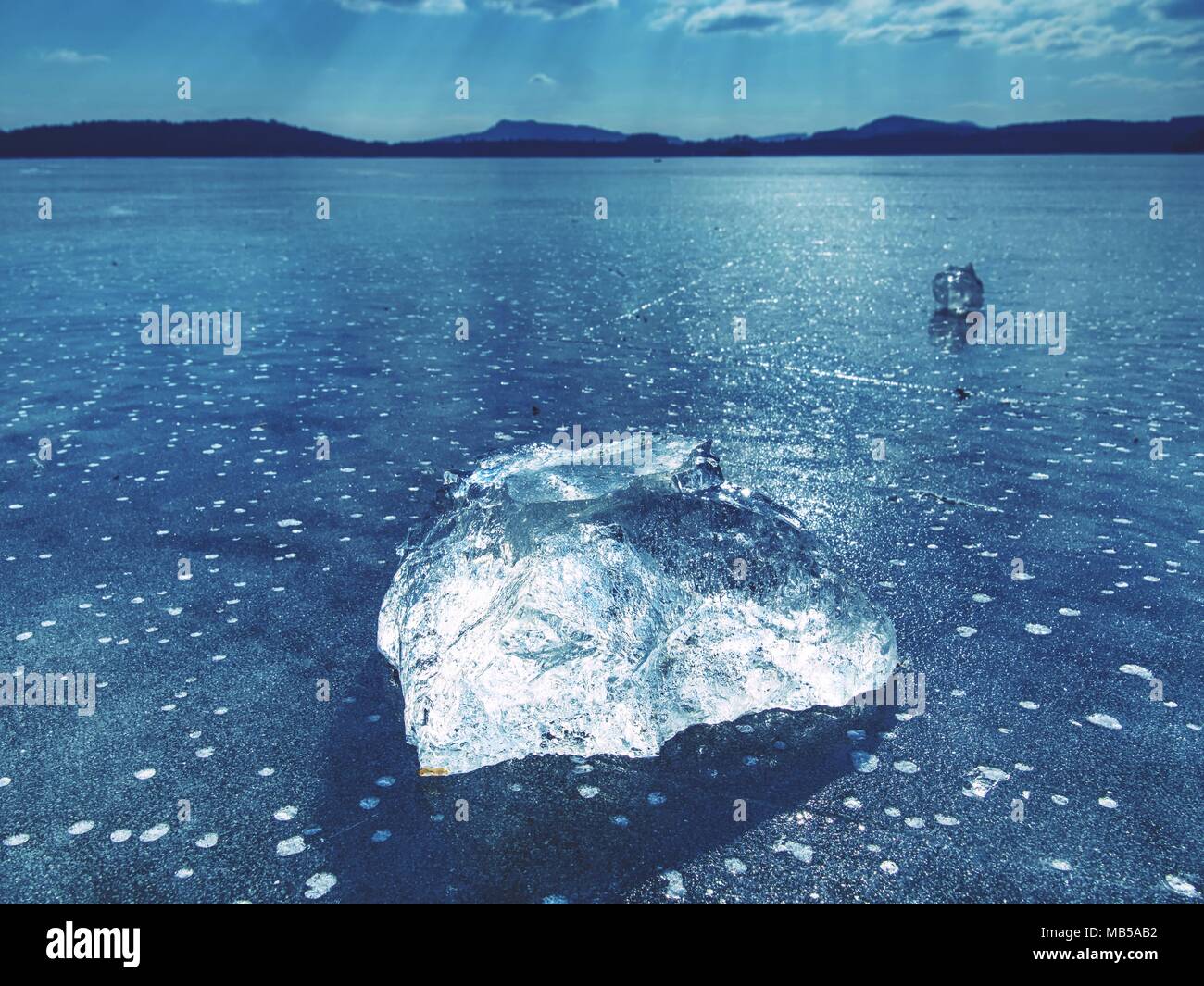 Sharp piece of ice. A symbol of harsh winter. The rays of the sun form ...