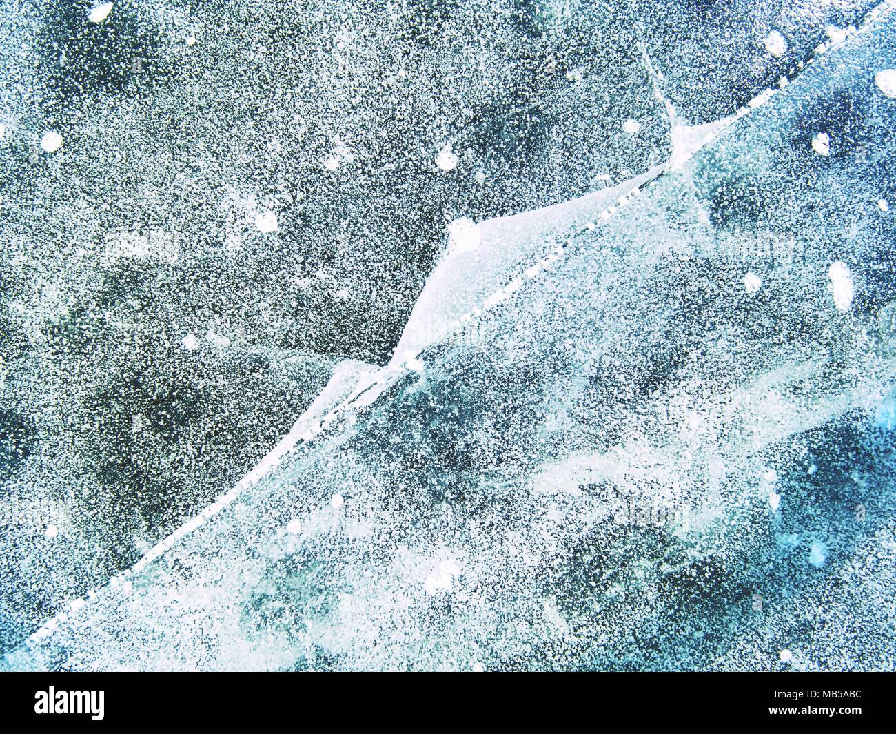 Bubbles frozen in thin ice. Colorful piece of ice with sun rays ...