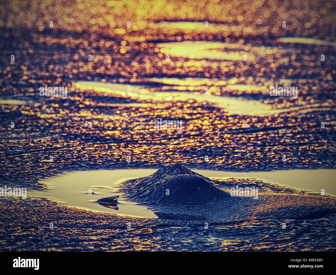 Shining icebergs and ice floes, ice clefts reflected rays in the smooth ...