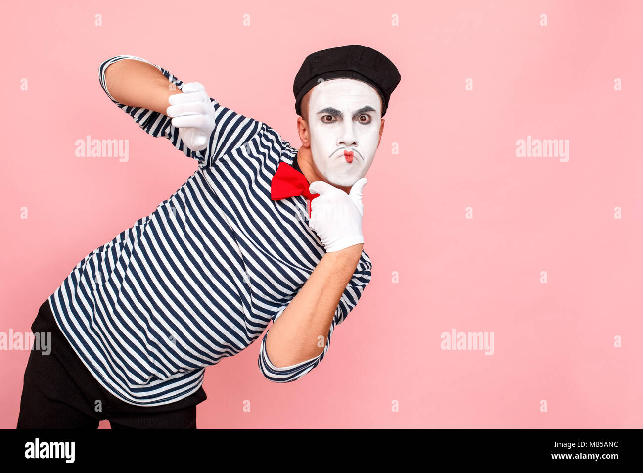 Puzzled man in striped sweater, white gloves with perplex face. Clown ...