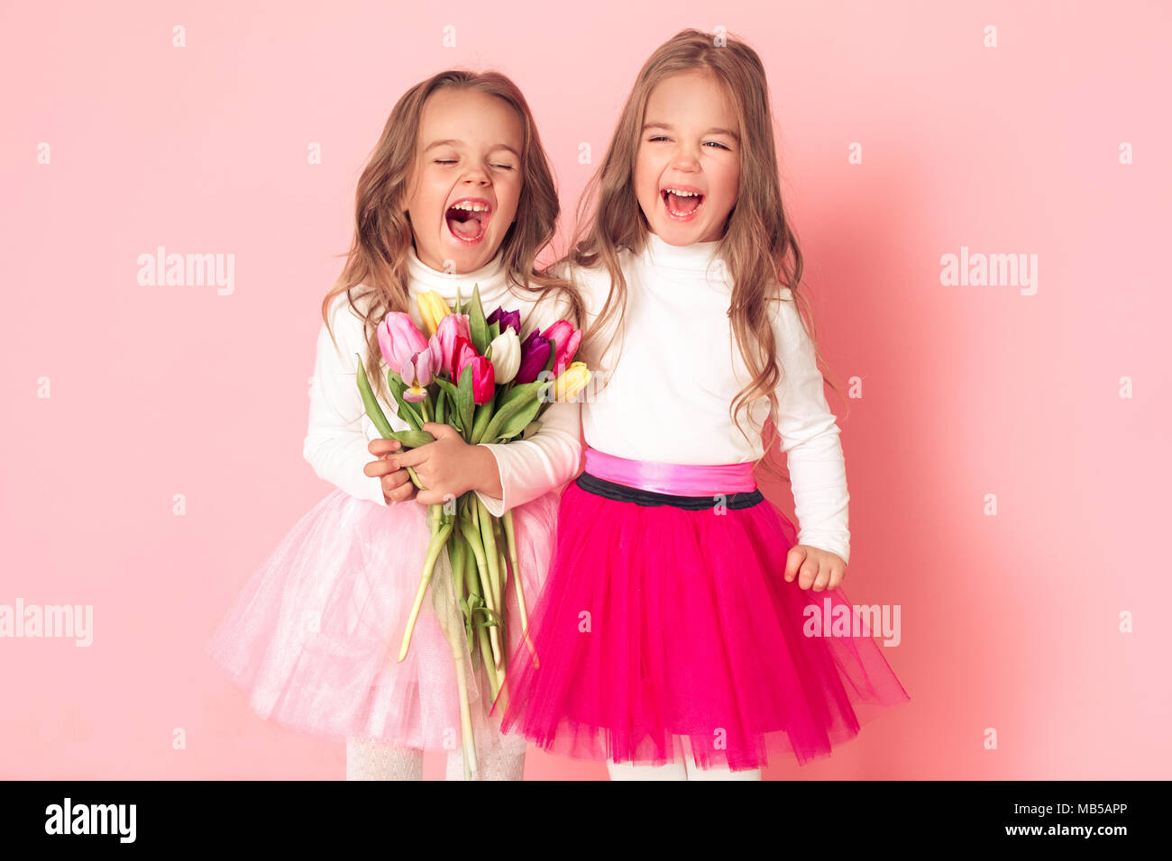 Two little children girls studio isolated on pink background easter ...