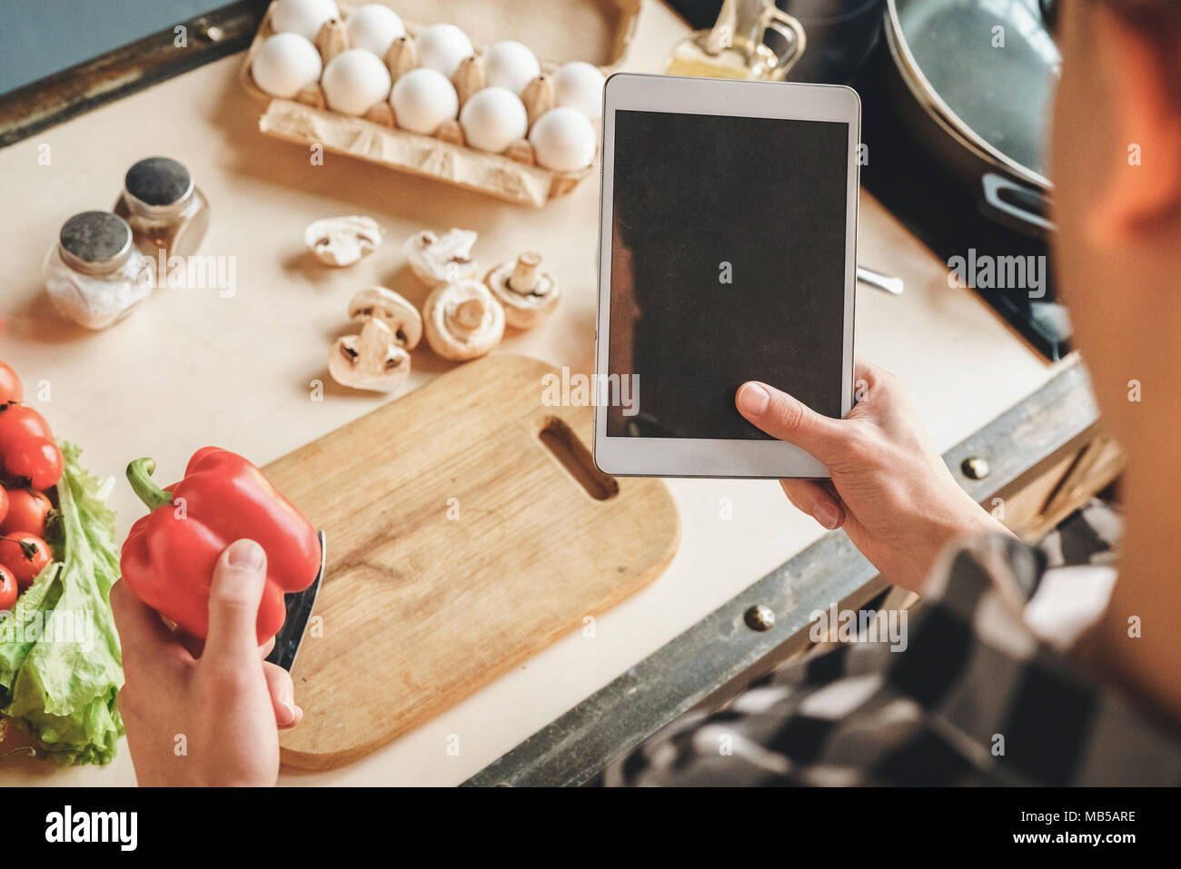 Young adult man watching video tutorials on cooking and slicing ...
