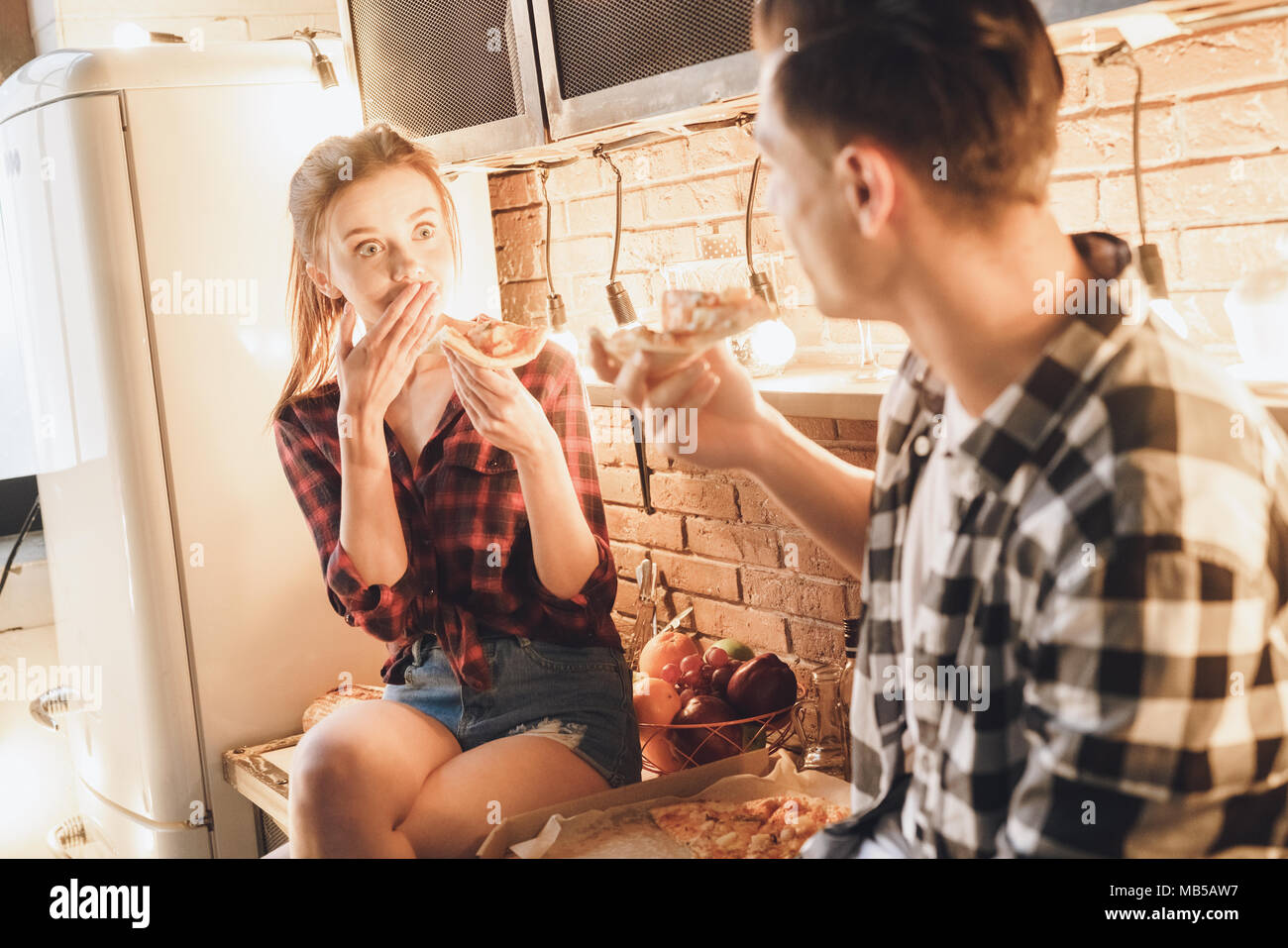 What, realy? Amazement woman with shocked face eating pizza. Indoor ...