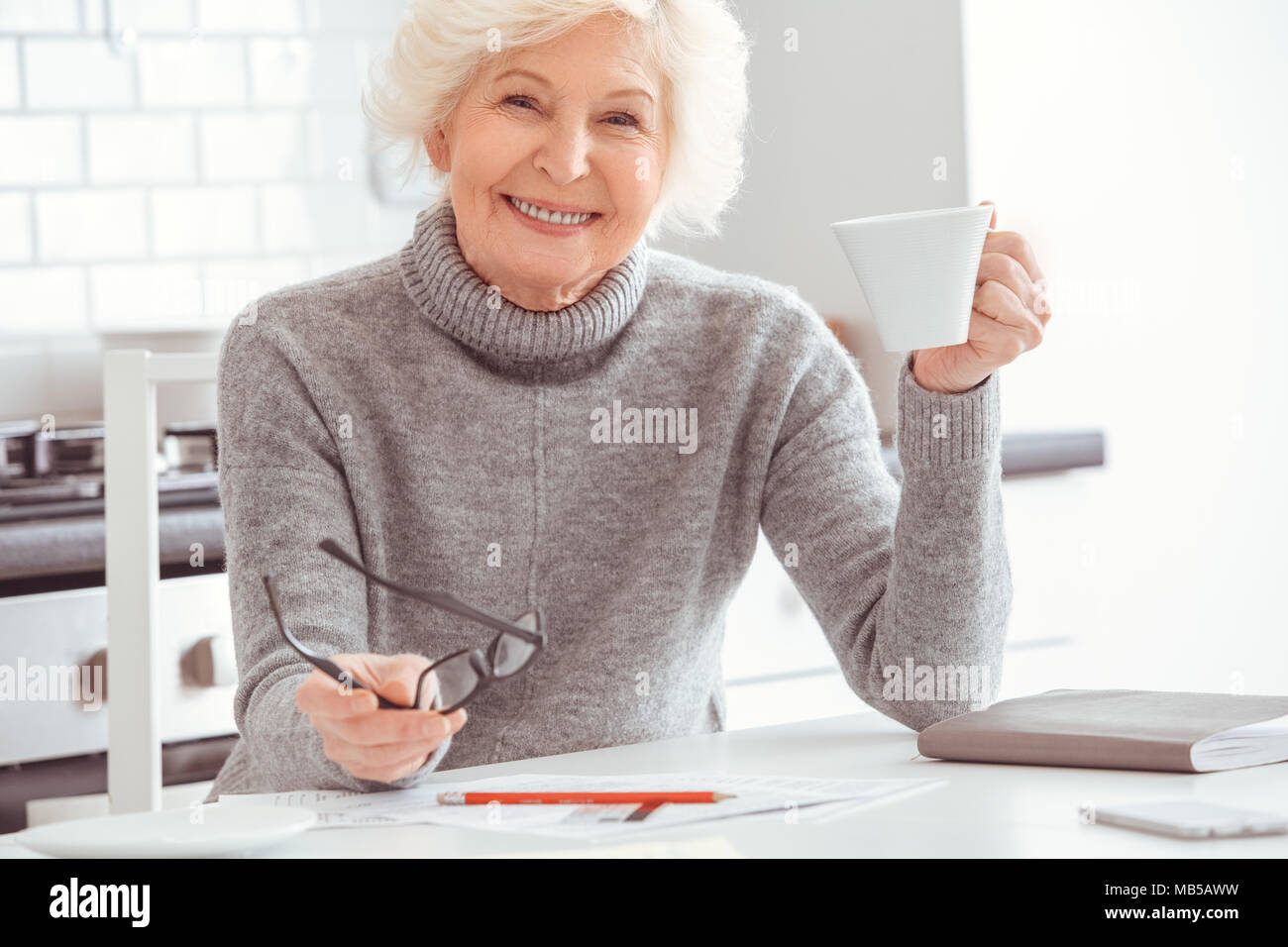 Happiness old woman in kitchen drink tea at the morning. Indoor, studio ...