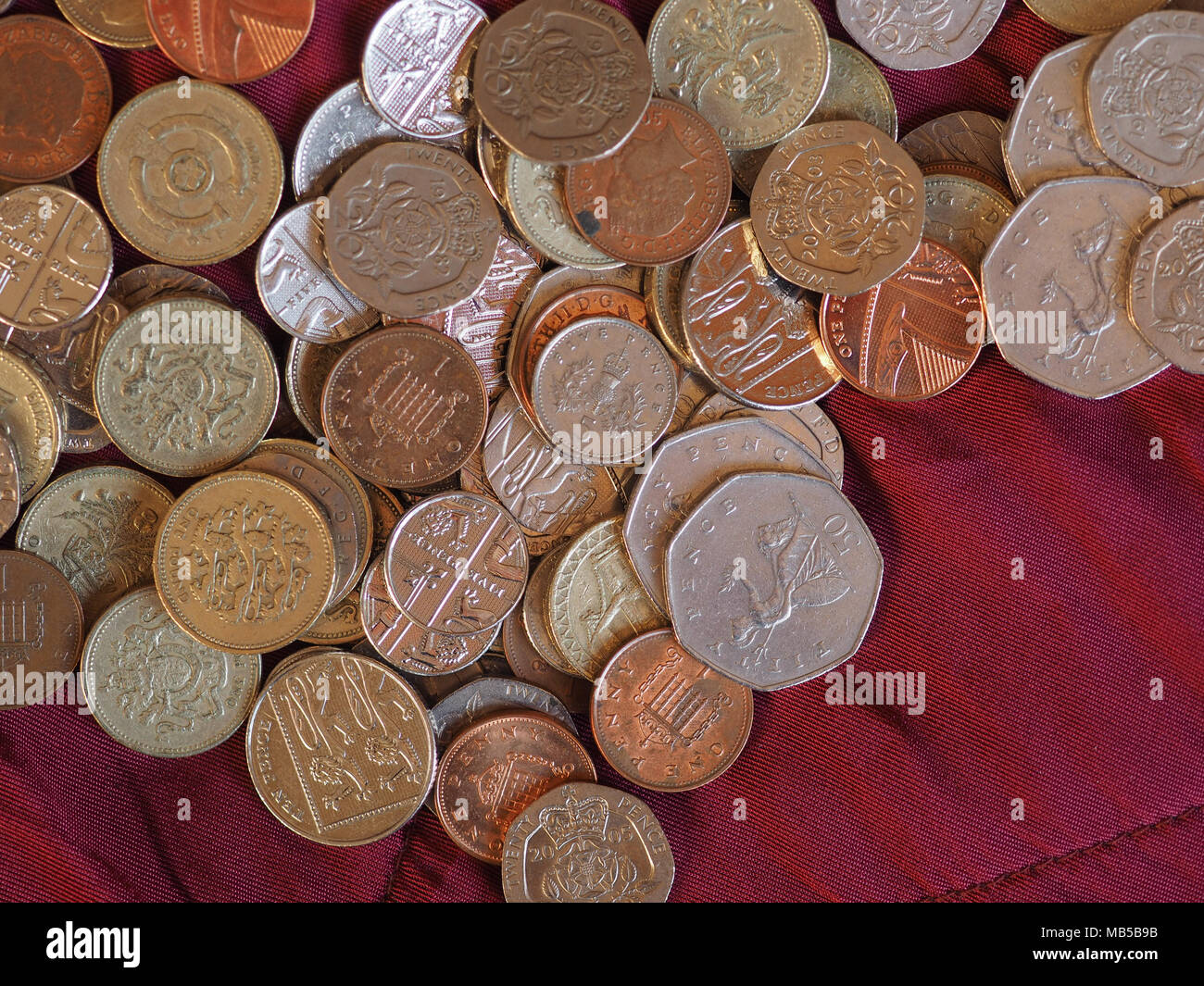 Pound coins money (GBP), currency of United Kingdom over crimson red ...