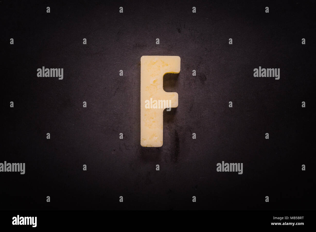 Butter Forms F on cast iron skillet background Stock Photo - Alamy