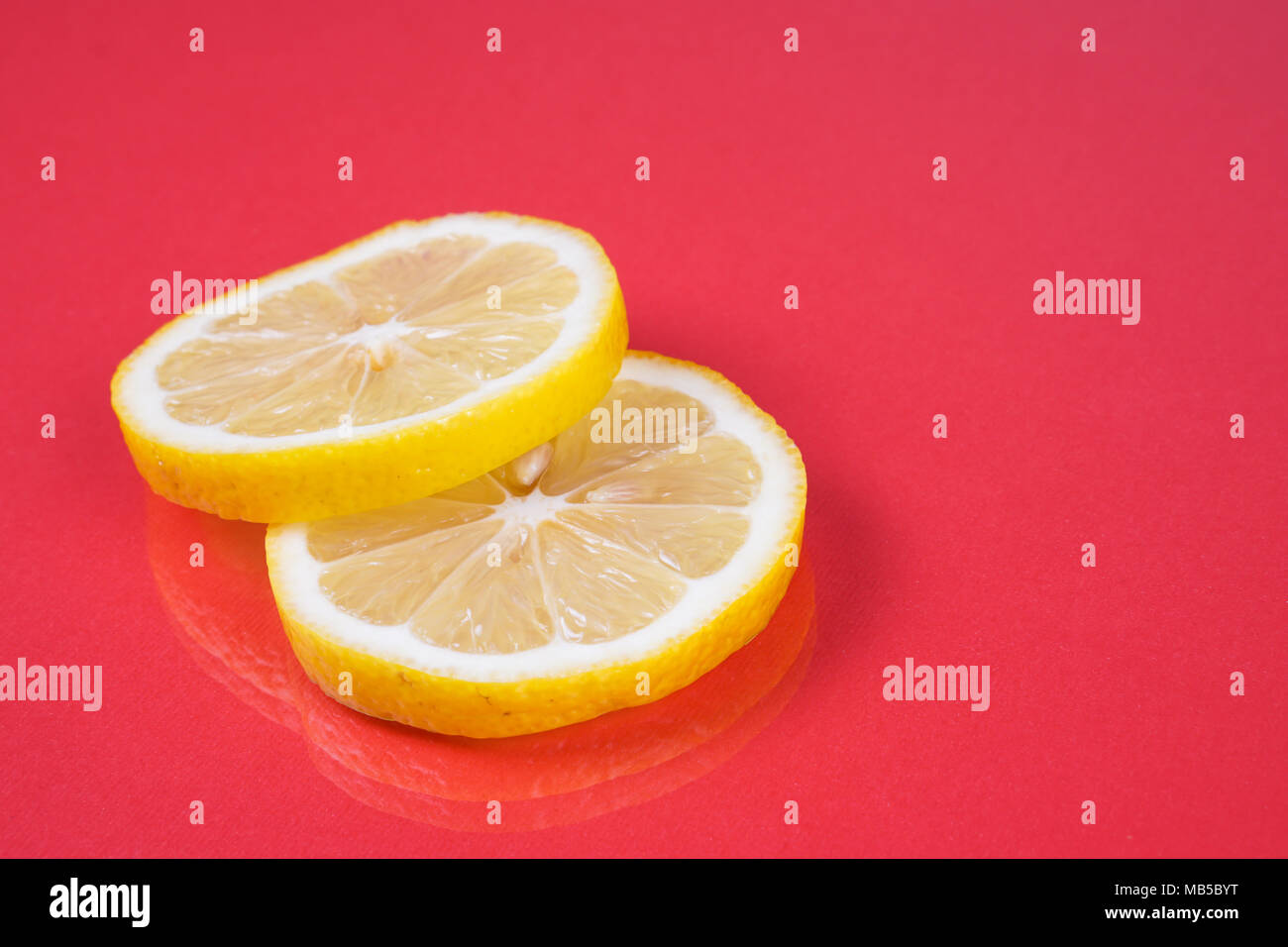 Lemon on red background Stock Photo - Alamy