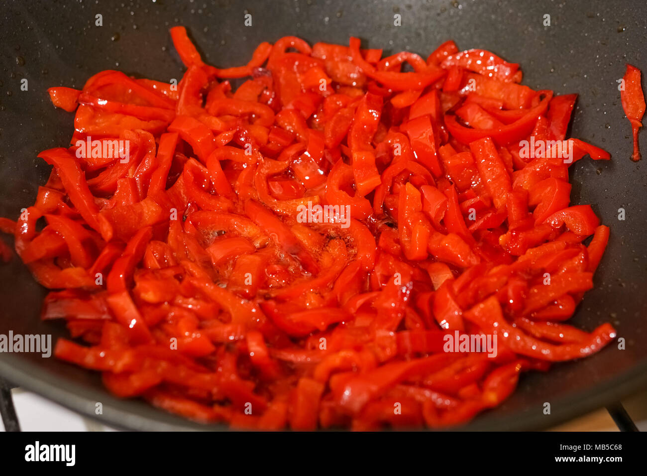 Preparation of cutted paprika in black frying pan Stock Photo - Alamy