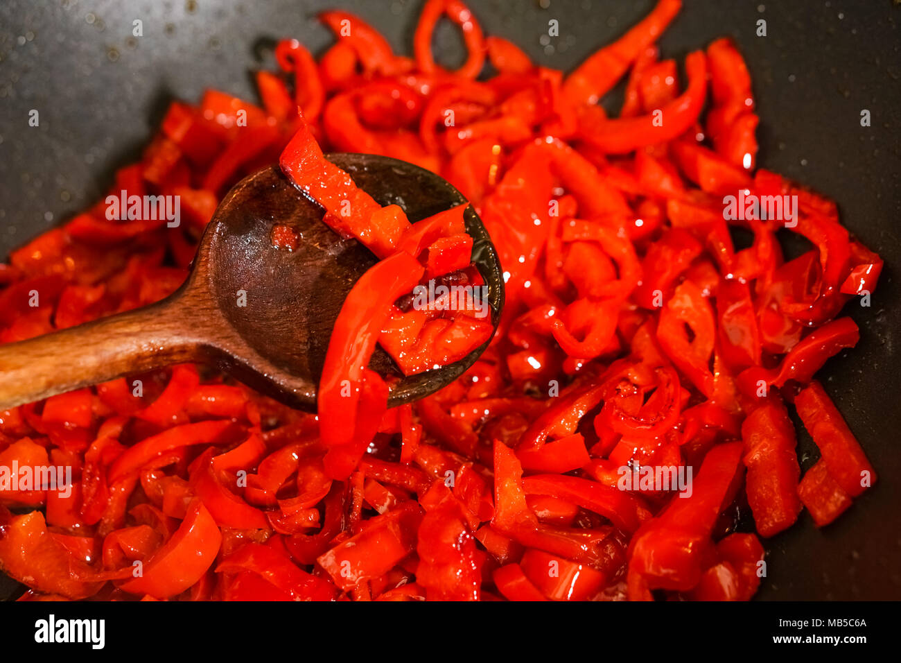 Preparation of cutted paprika in black frying pan Stock Photo - Alamy