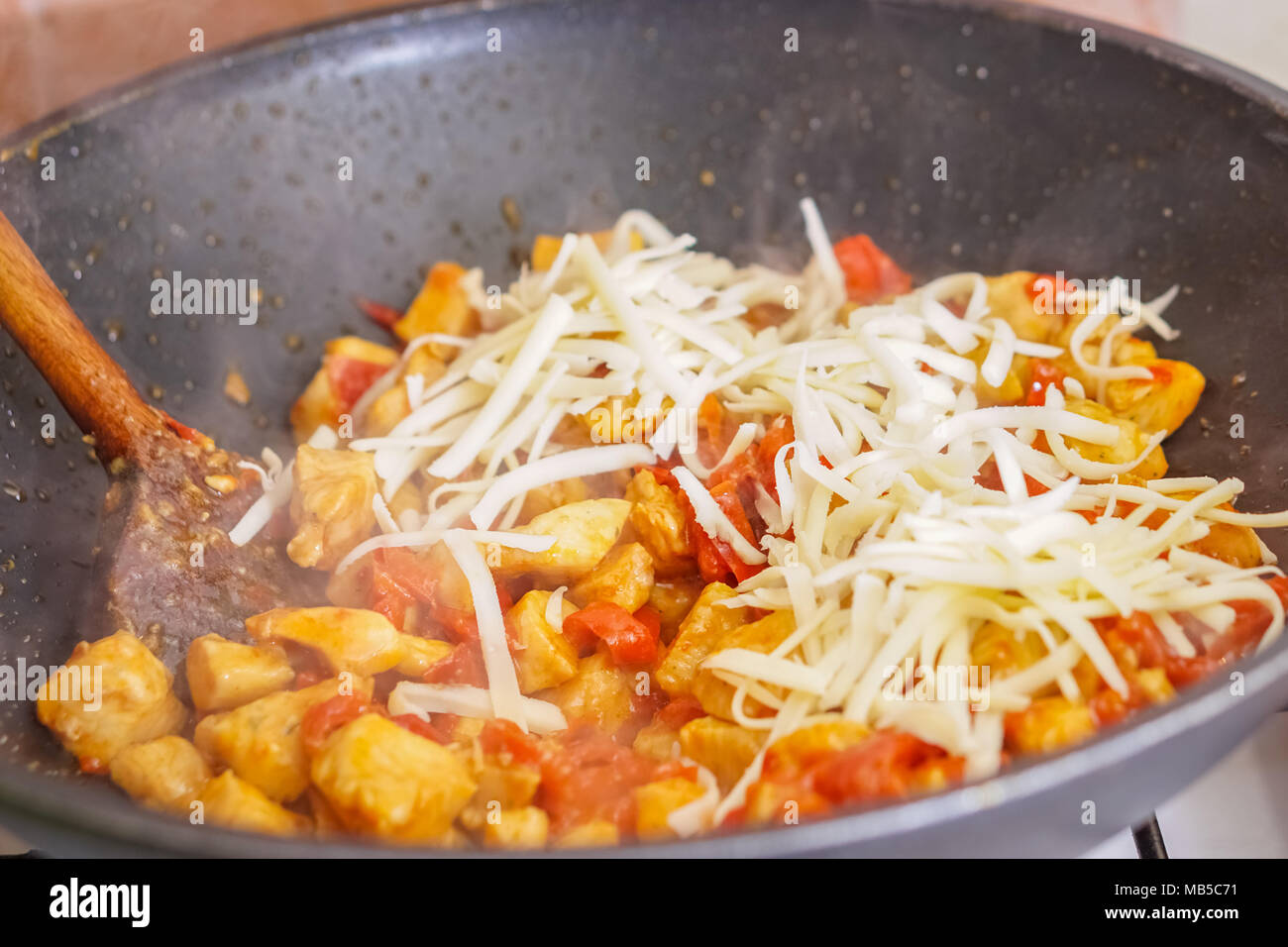 Preparation of cutted paprika with chicken meat and cheese in black ...