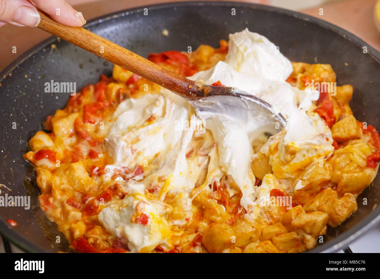 Preparation of cutted paprika with chicken meat and cheese in black ...