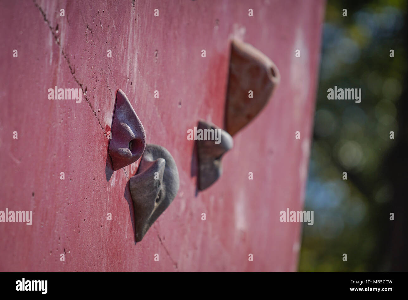 Red artificial climbing wall with holds outdoor Stock Photo - Alamy