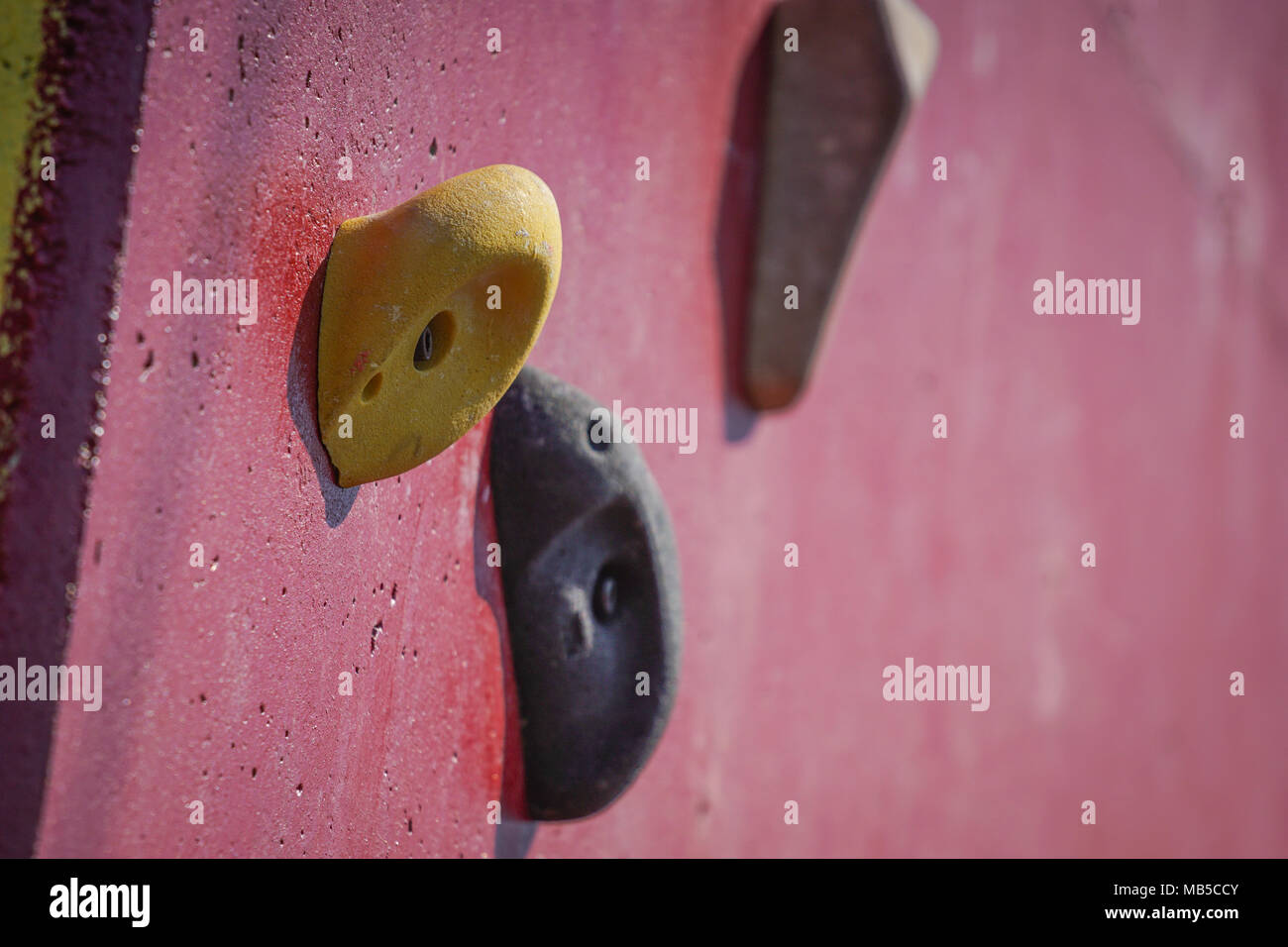 Red artificial climbing wall with holds outdoor Stock Photo - Alamy