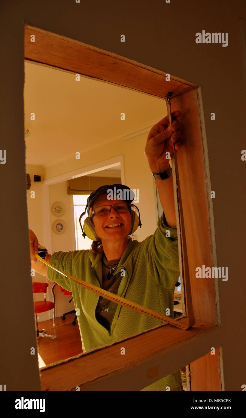 The cutter is measuring the space between timber house studs to get the ...