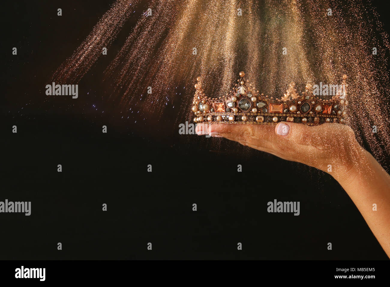 Woman's hand holding a crown for show victory or winning first place ...