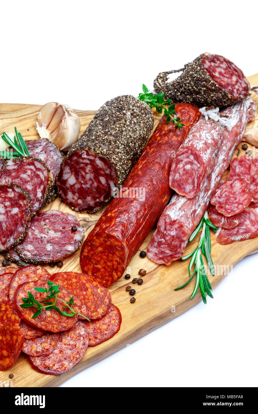 Various types of Dried organic salami sausage on wooden cutting board ...