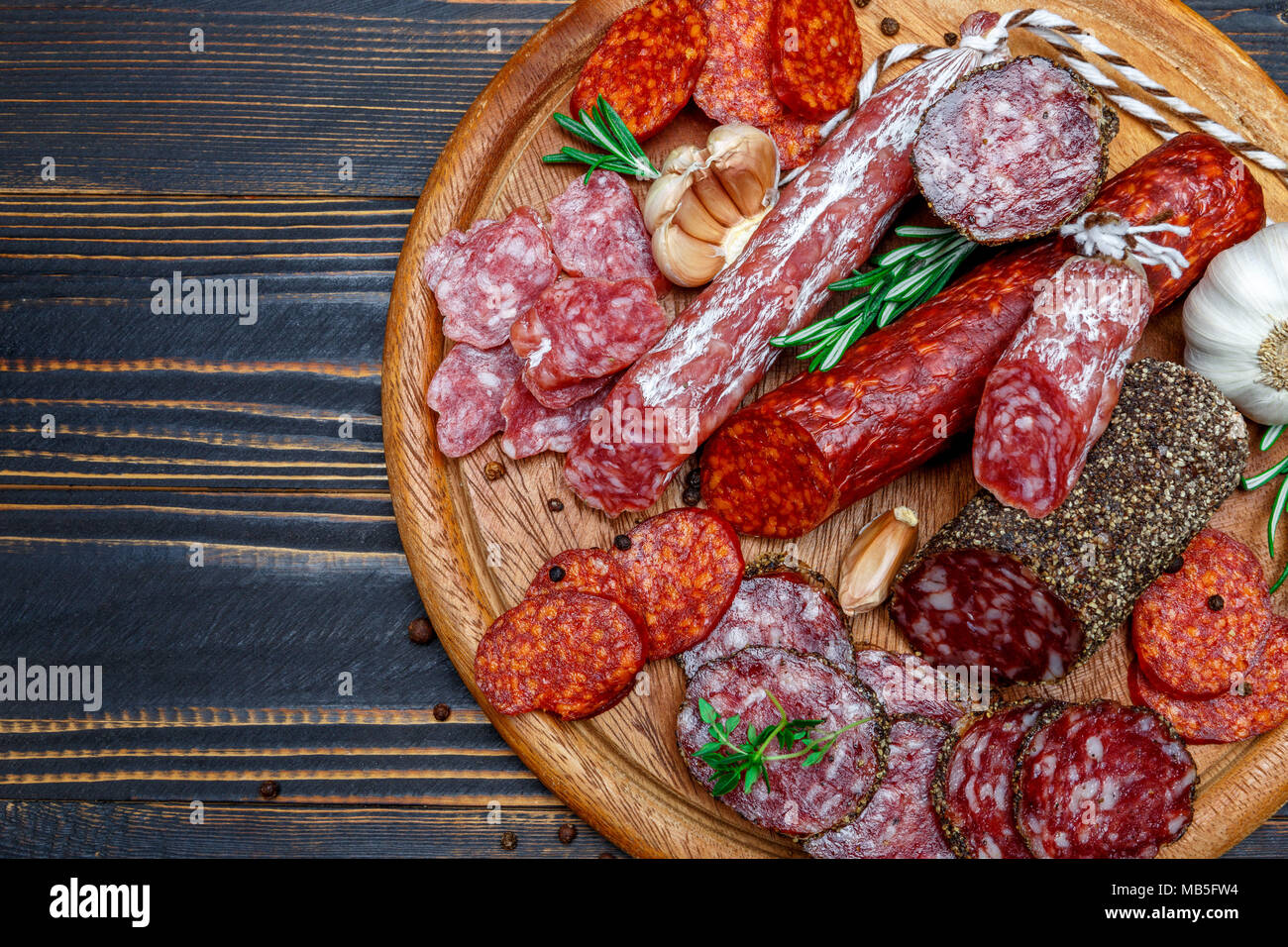 Various types of Dried organic salami sausage on wooden cutting board ...