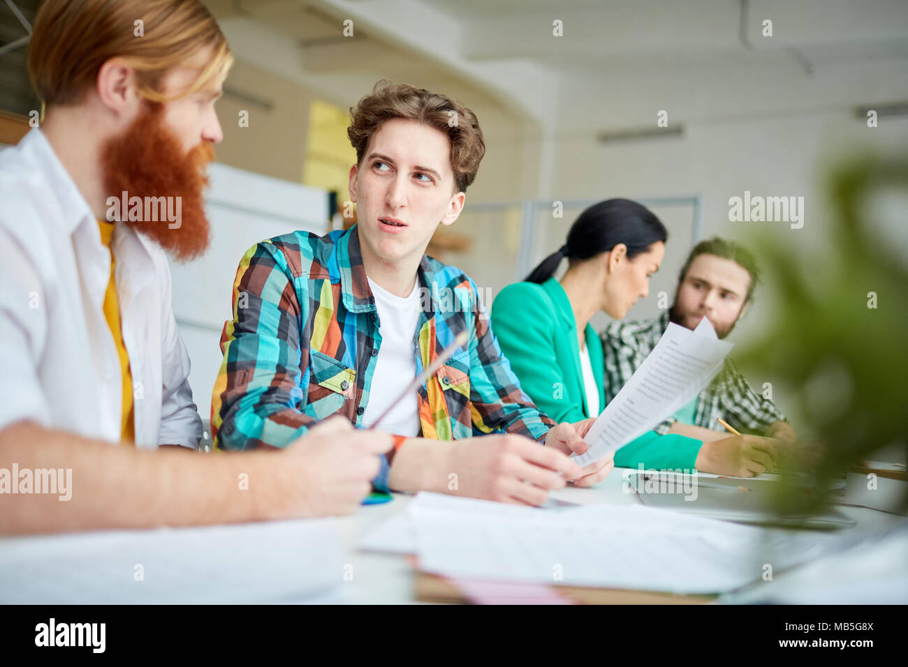 Business people sitting at the table and working with documents and ...