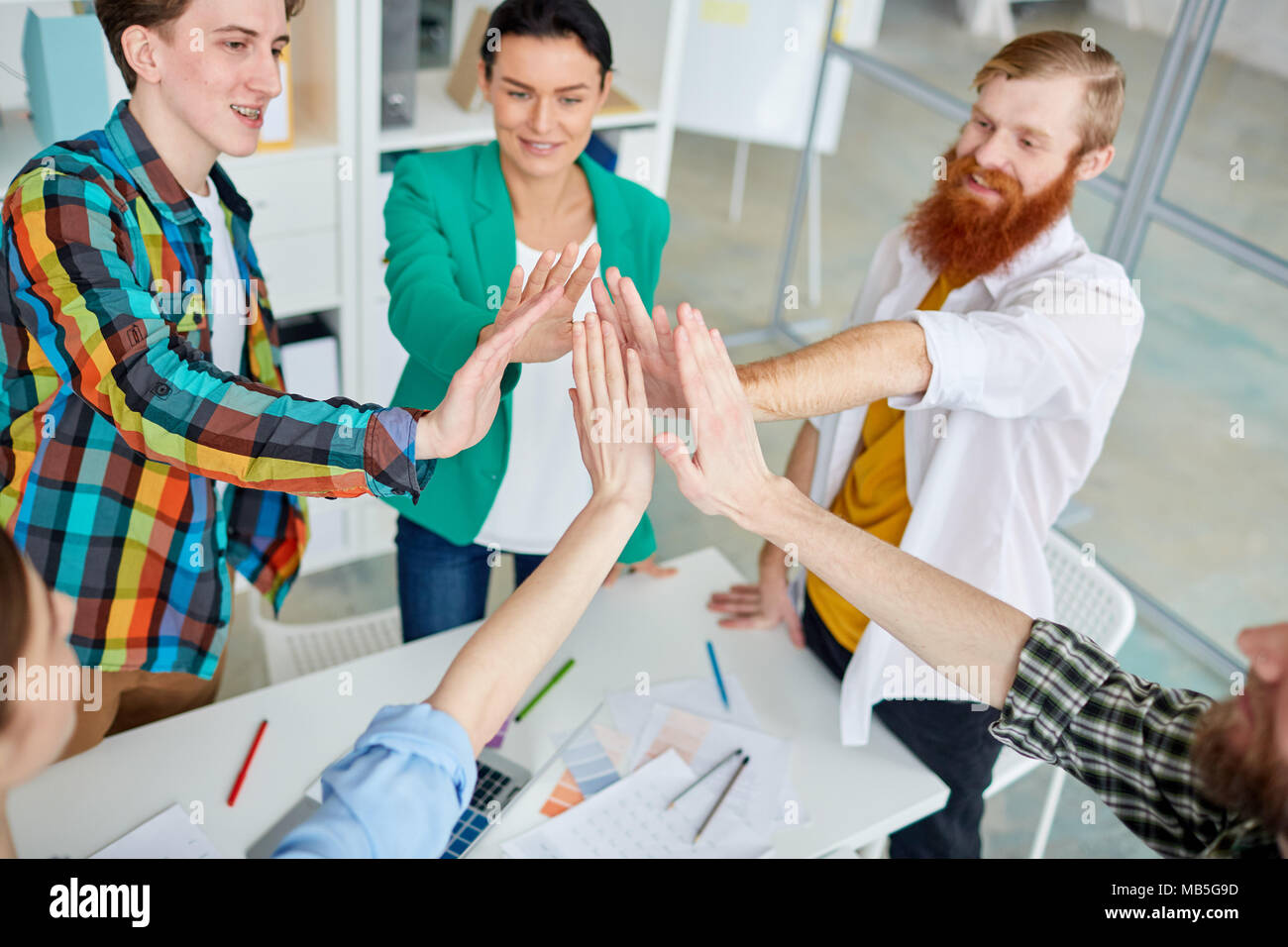 Group young business colleagues giving high five after success work ...