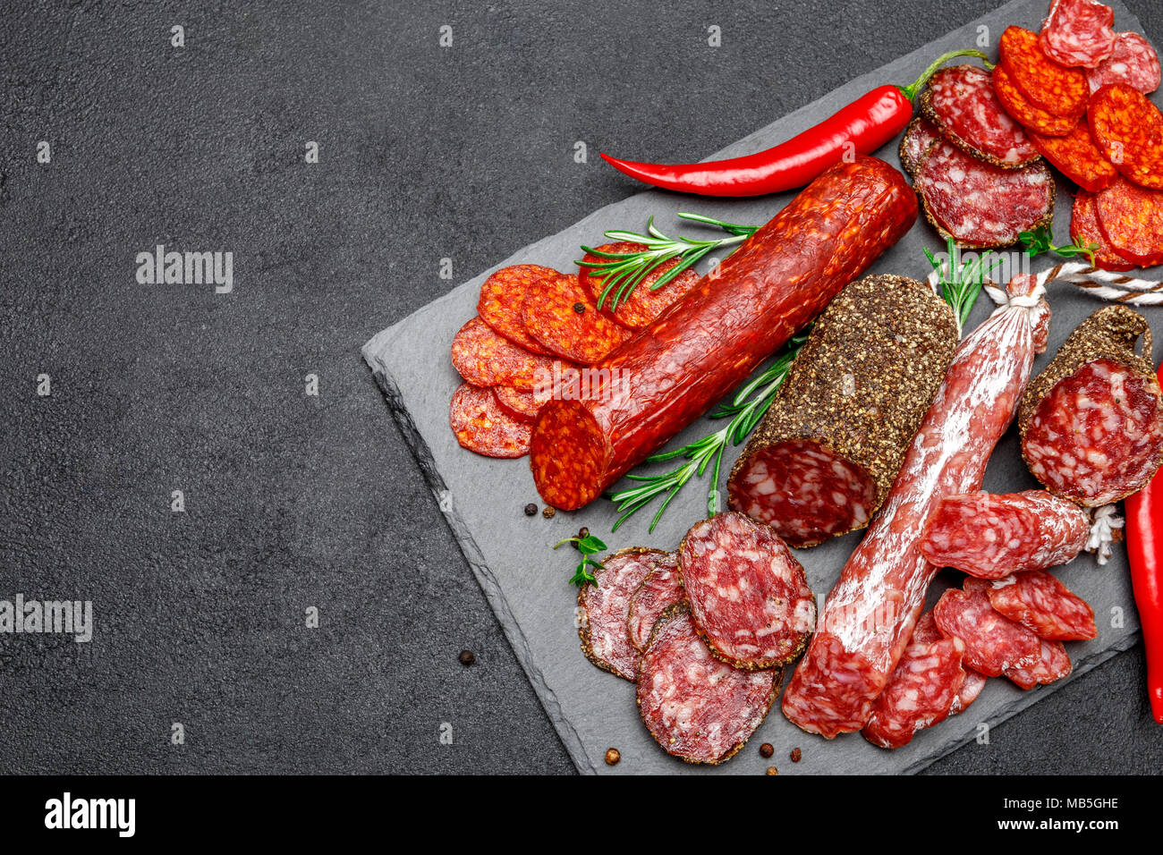 Various types of Dried organic salami sausage on stone serving board ...