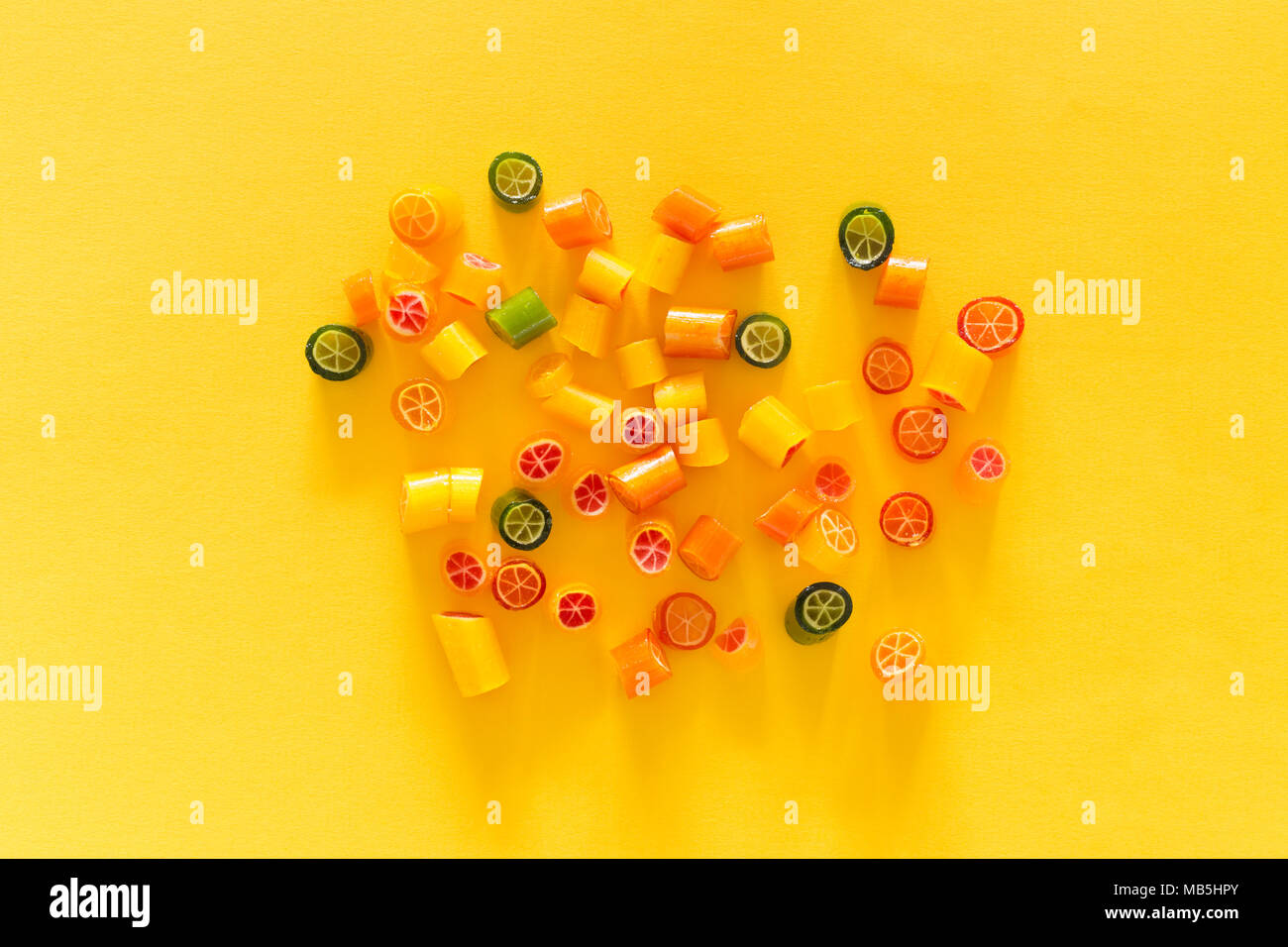 Assortment of colorful sweet handmade candy pieces arranged on yellow ...