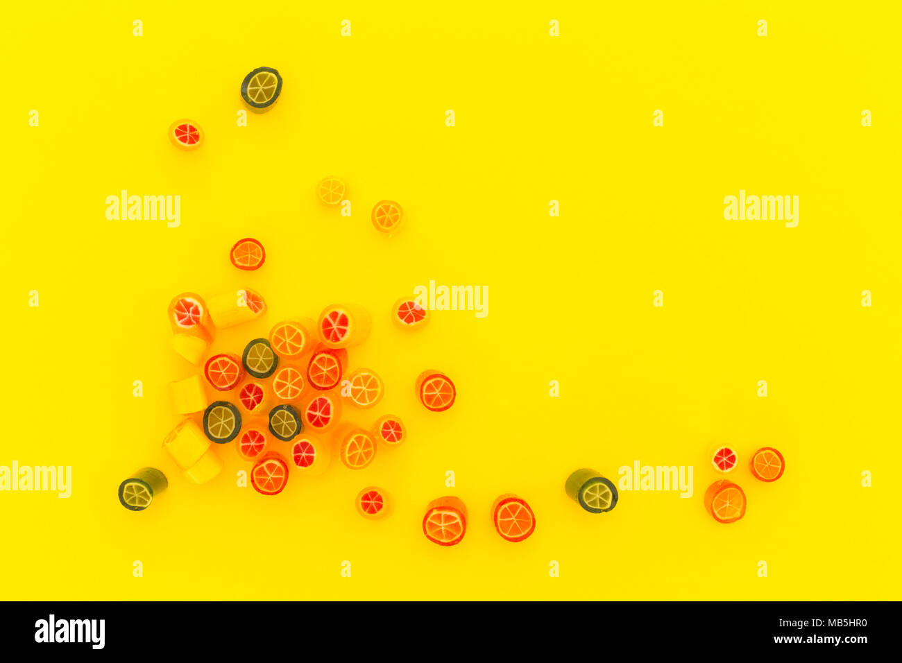 Assortment of colorful sweet handmade candy pieces arranged on yellow ...