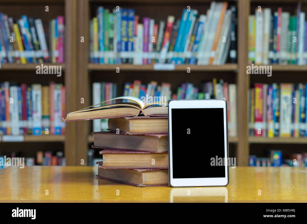 old book on the desk in library with tablet Stock Photo - Alamy