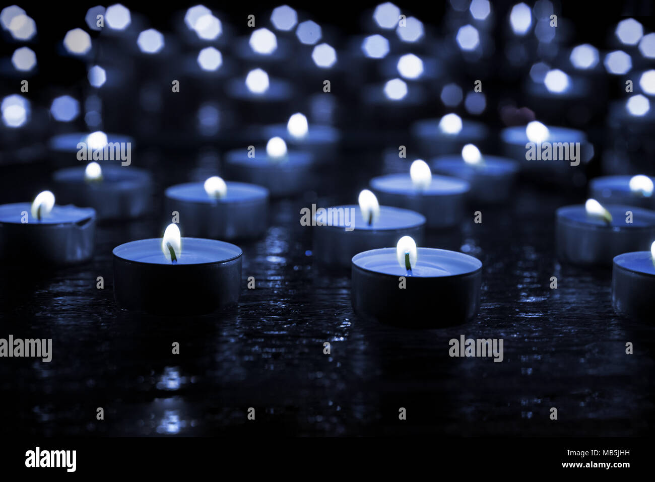 Burring candles on decorative glass. Dark background. Abstract photo ...