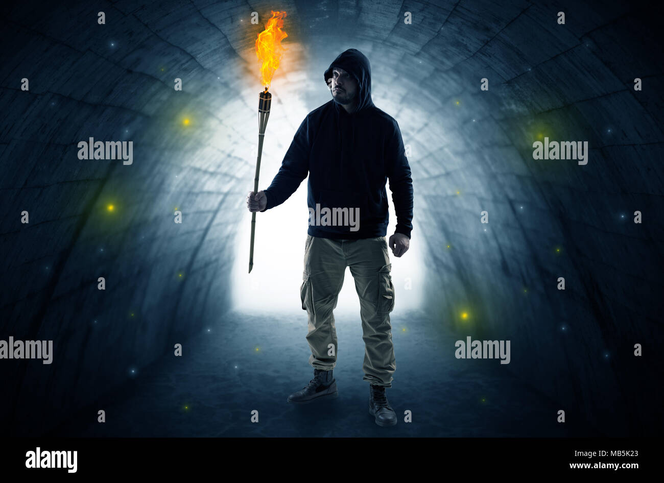Ugly man with burning flambeau walking in a dark tunnel Stock Photo - Alamy