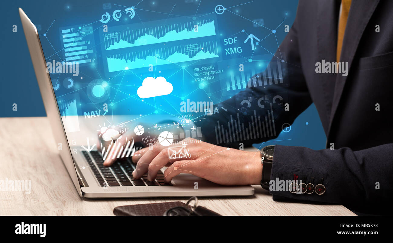 Businessman hand typing on laptop with reports and graphs concept ...