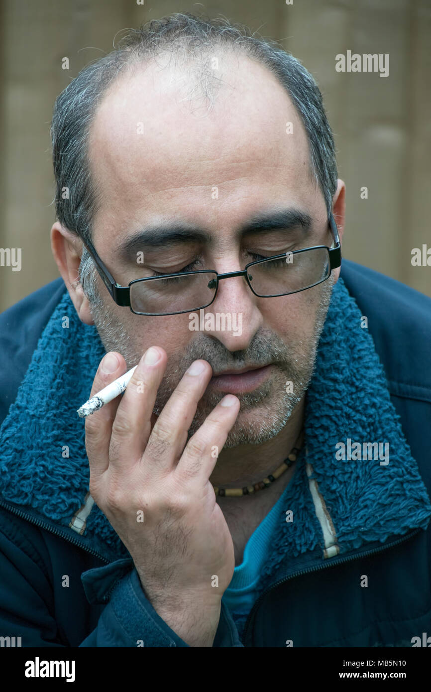Sad man smoking cigarette hi-res stock photography and images - Alamy