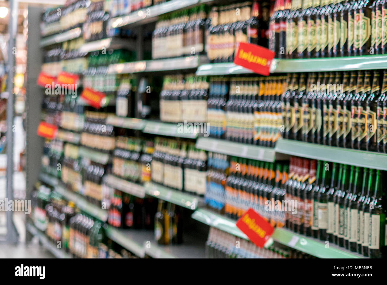 Different types of beer on the shelves in the supermarket. blurry Stock ...