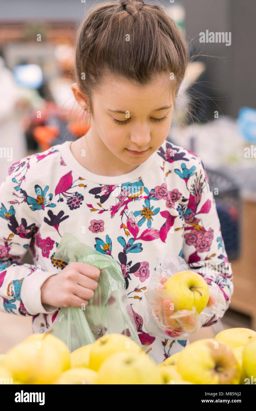 Little girl choosing a bio apple in a store Stock Photo - Alamy