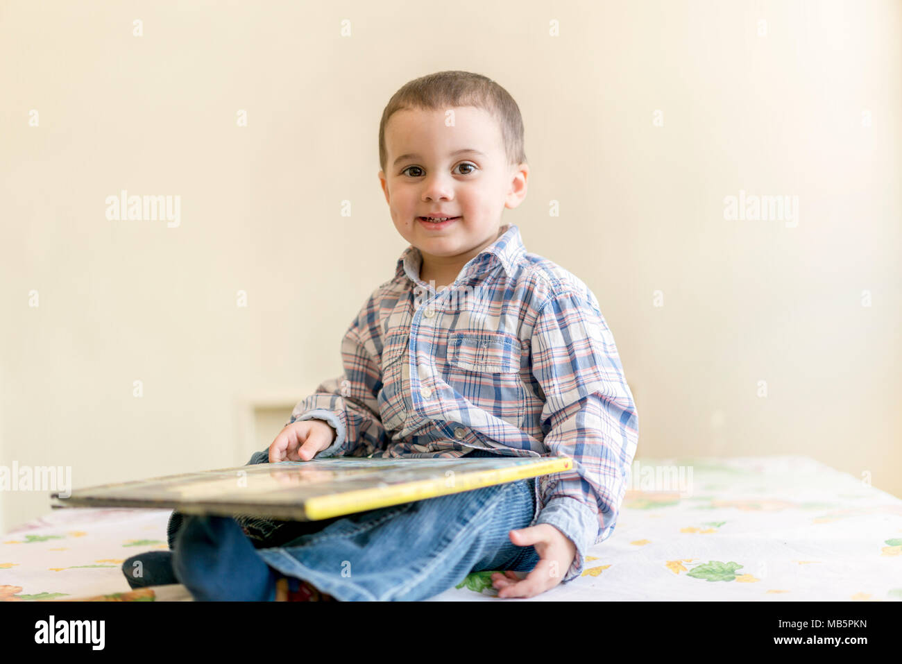A beautiful little boy is looking at a big book Stock Photo - Alamy