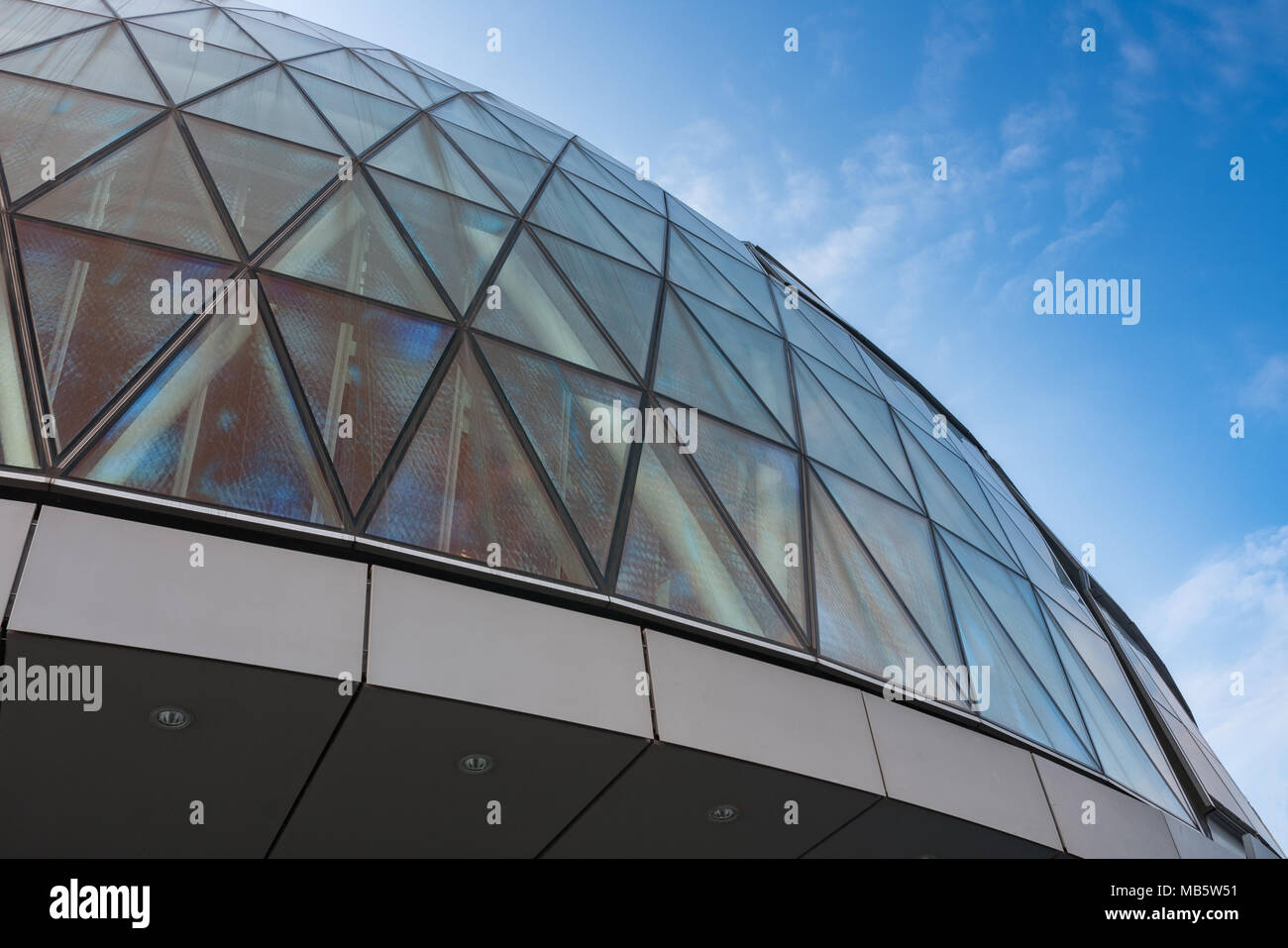 Spherical roof and glass facade of modern skyscraper, blue sky on ...